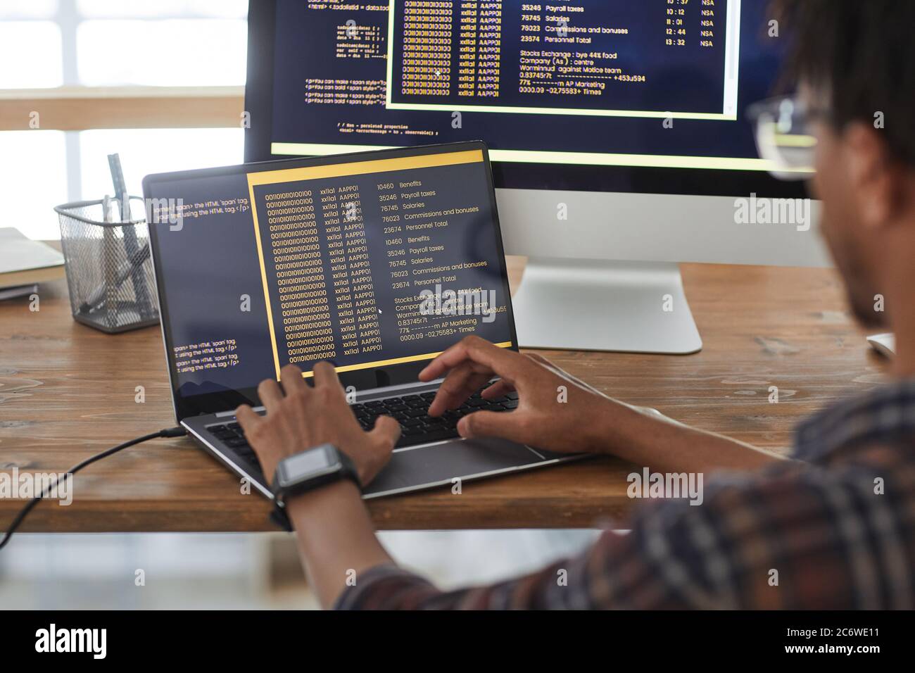 Back view at African-American IT developer typing on keyboard with ...