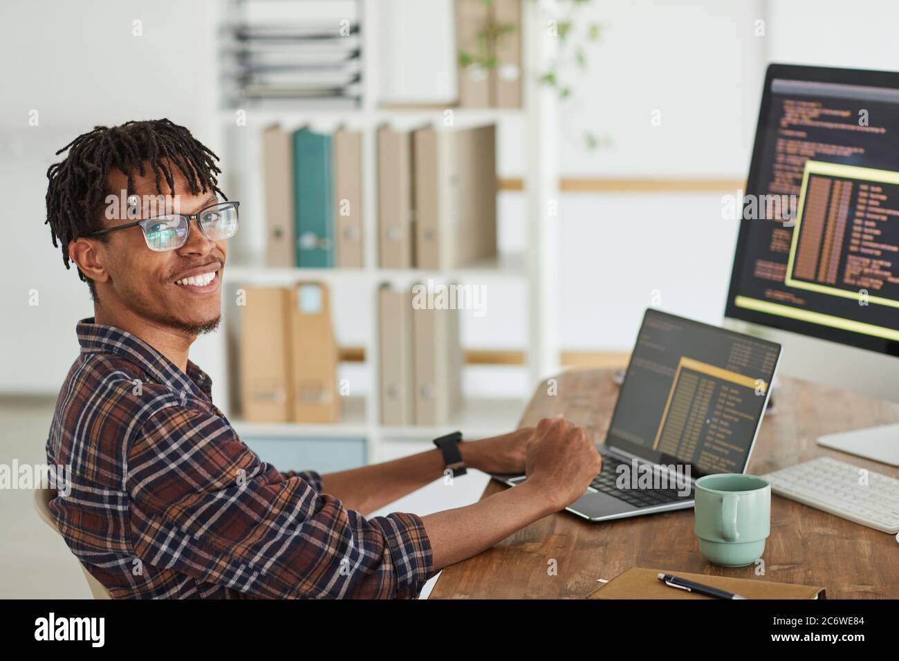 Portrait of smiling African-American IT developer looking at camera ...