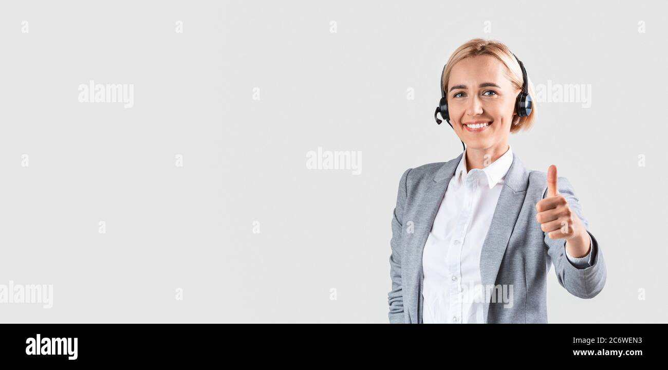 Happy tech support service worker with headset showing thumb up against ...