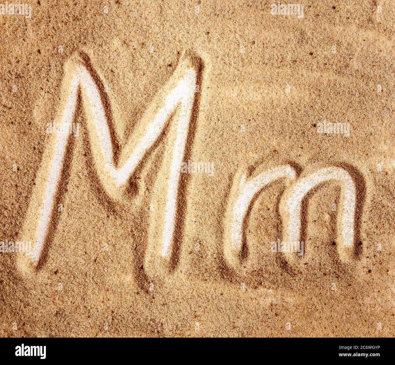 Letter M. English Handwritten Alphabet In The Sand Stock Photo - Alamy