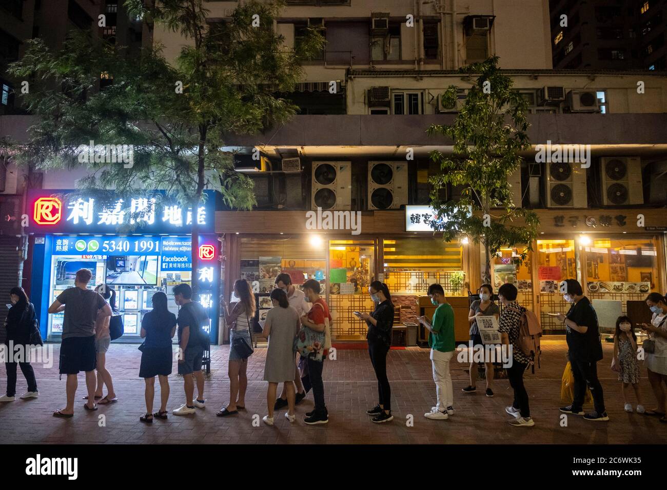 Hong Kong, China. 12th July, 2020. People queue up at a temporary ...