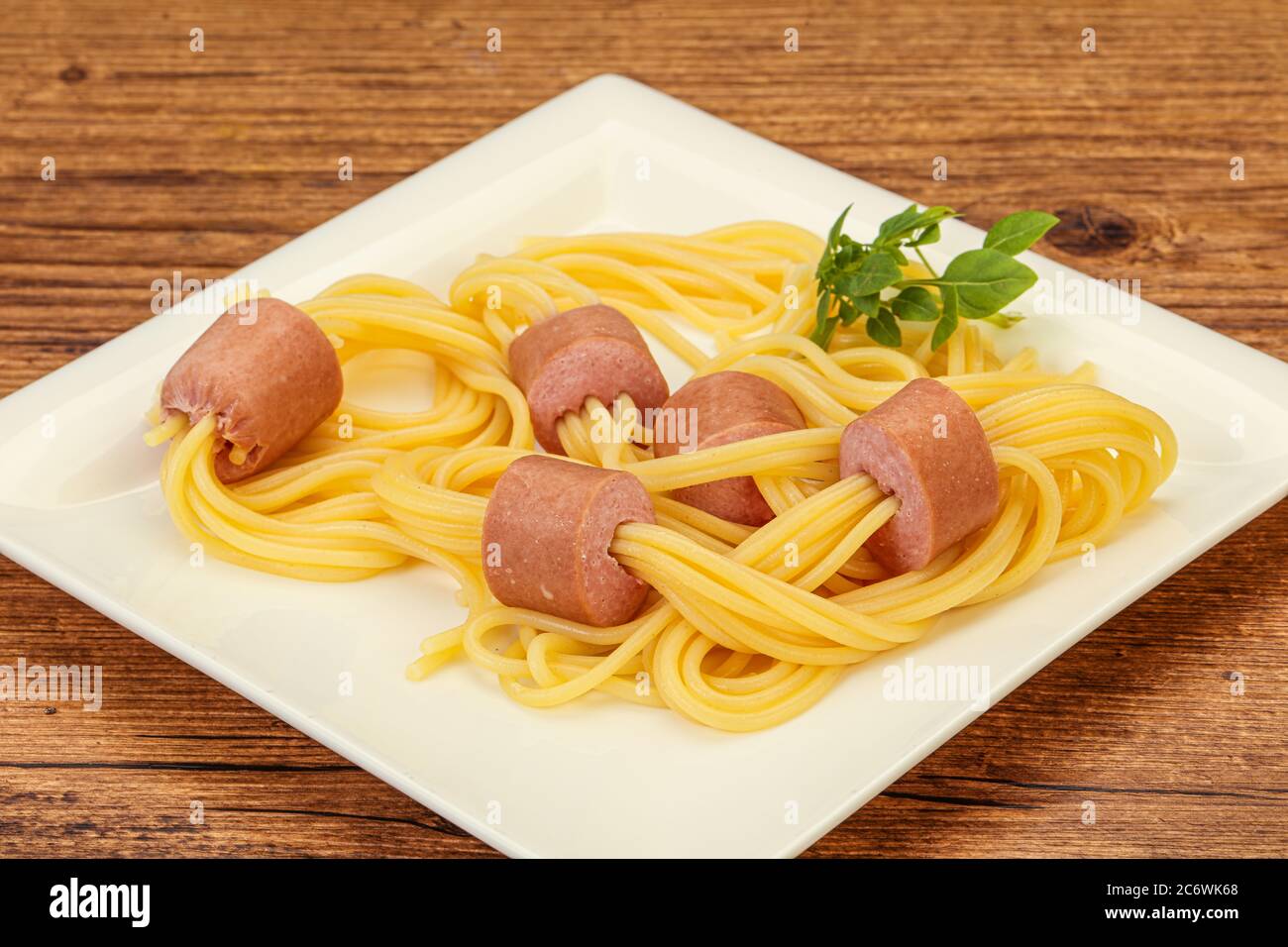 Kids pasta spaghetti with sausages and basil Stock Photo - Alamy