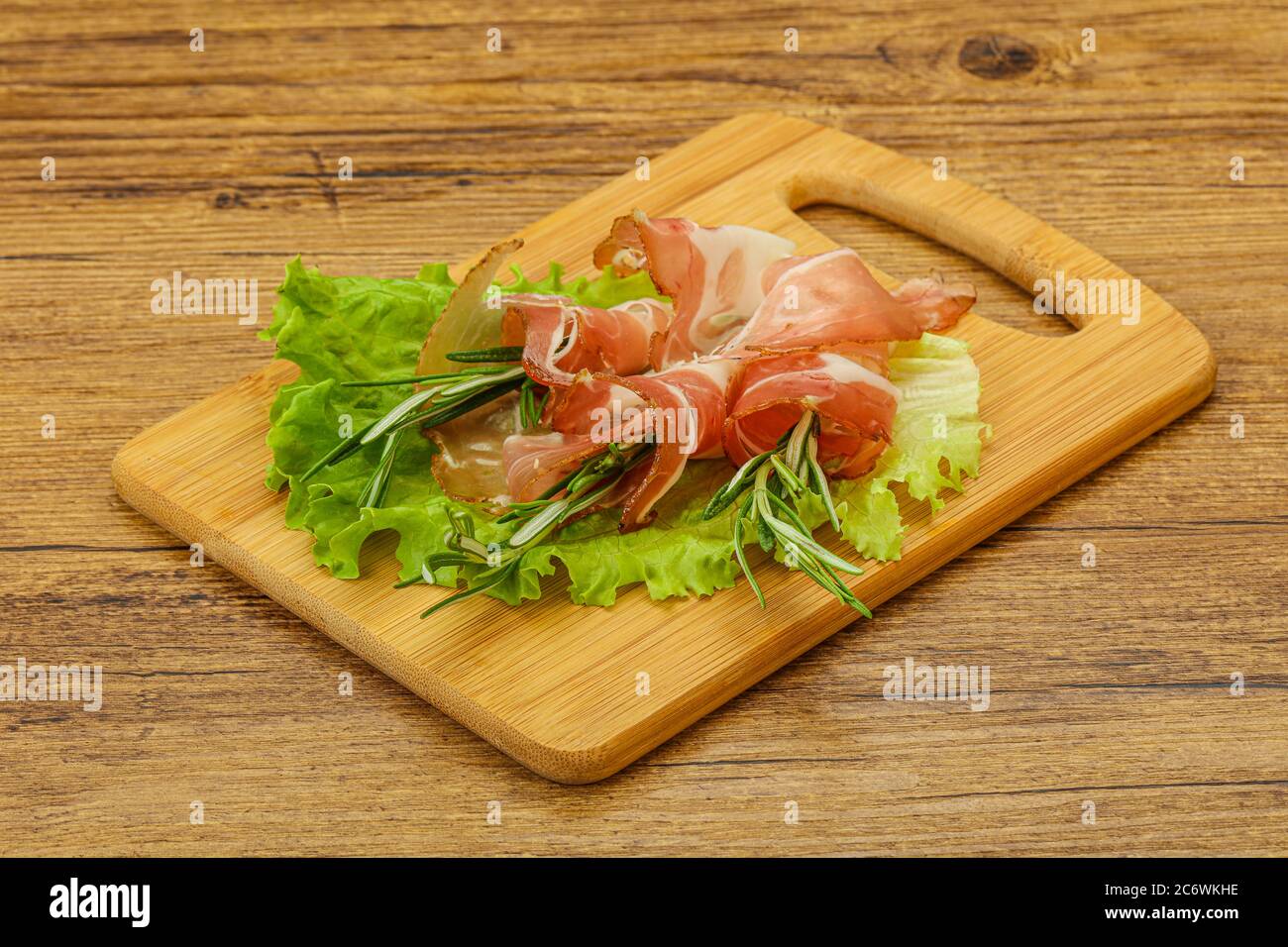 Sliced pork Jamon meat with rosemary Stock Photo - Alamy