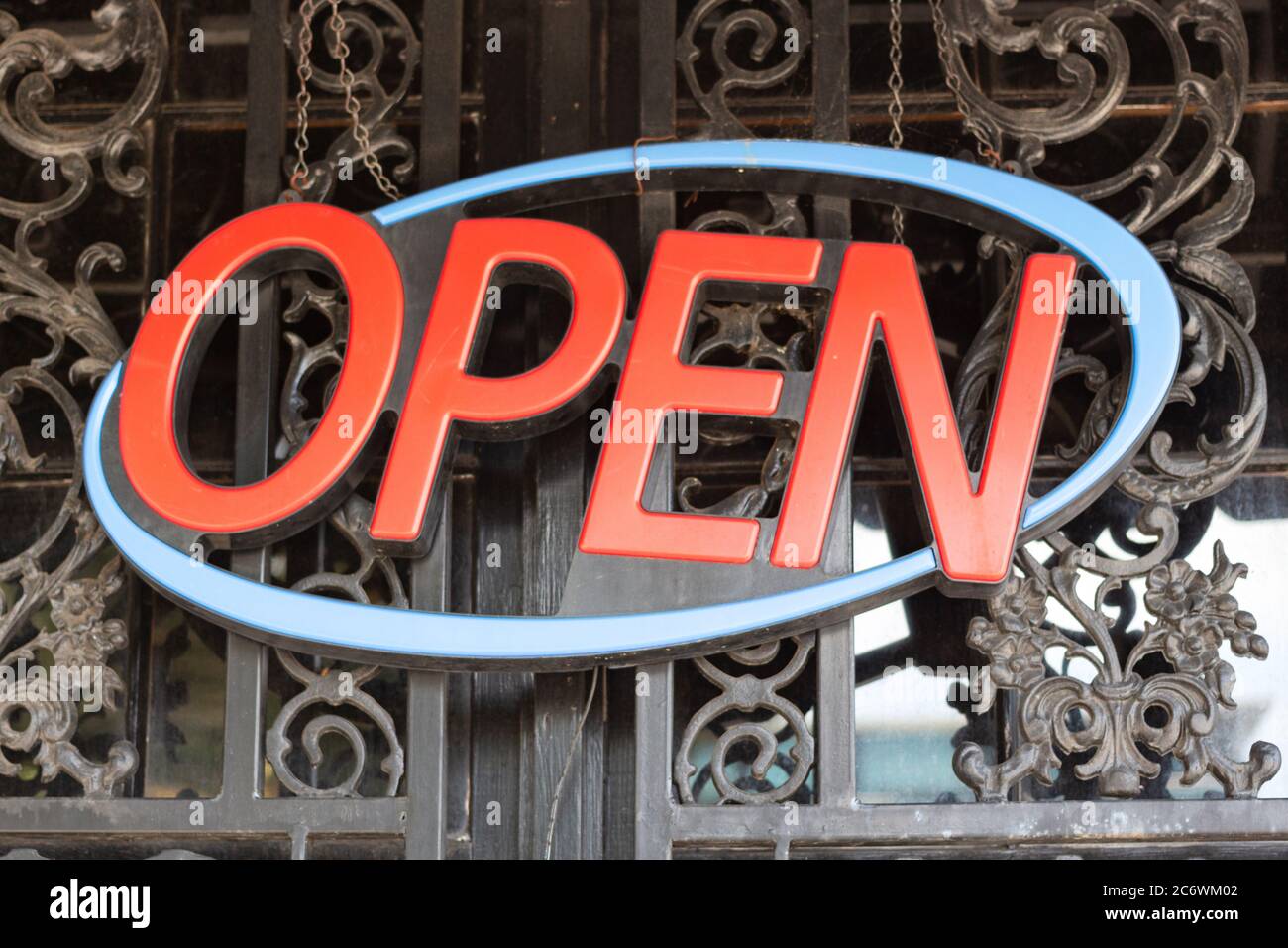 A red sign on a door with a wrought iron grating proclaims the business ...
