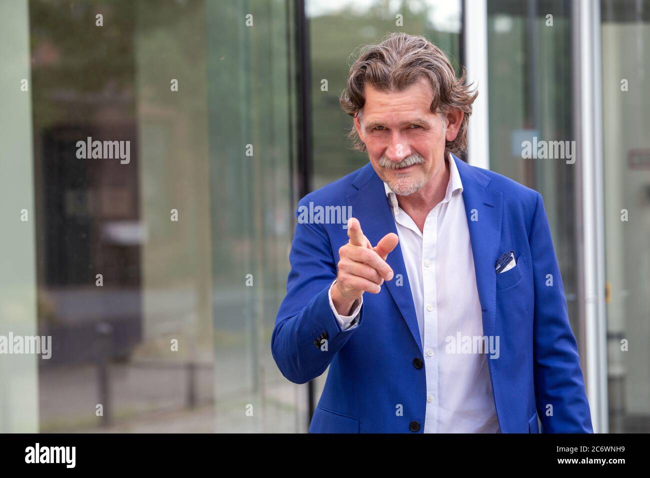 portrait of businessman in his 50s standing outside pointing finger to ...