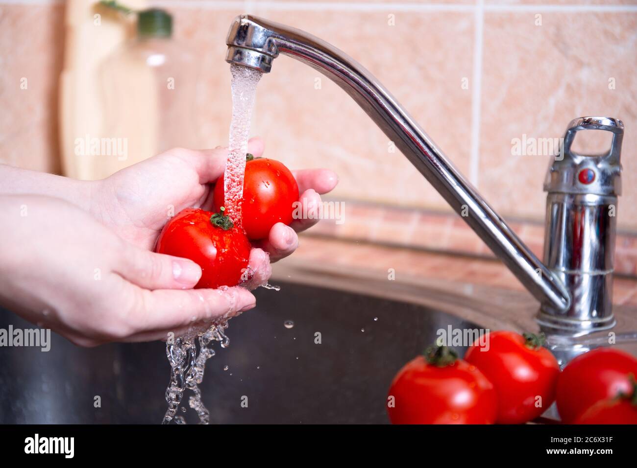 Washing vegetables under the sweat of water in the sink. Hard hands ...
