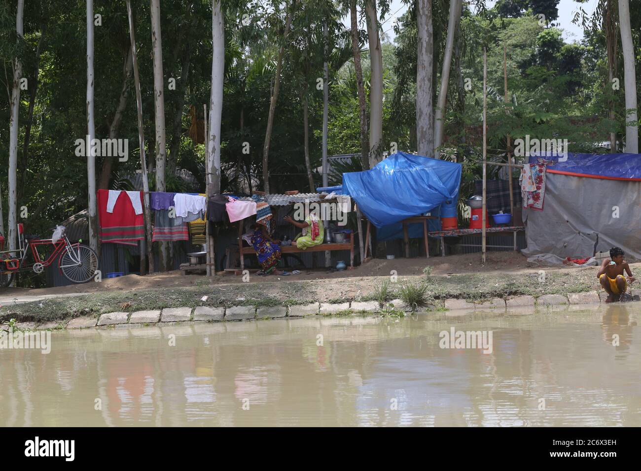 Flood affected people take shelter on a dam during the monsoon flood in ...