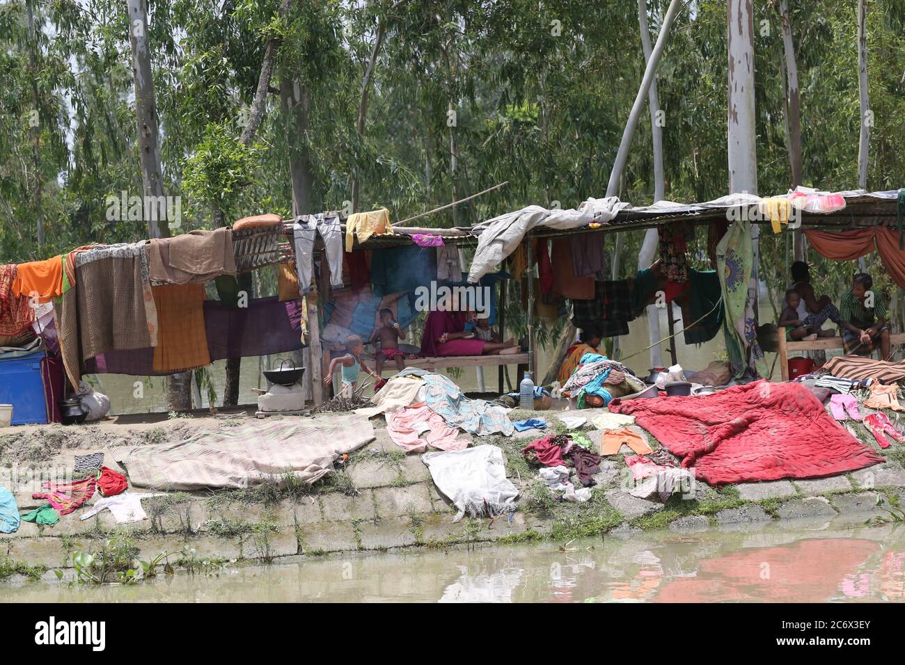 Flood affected people take shelter on a dam during the monsoon flood in ...