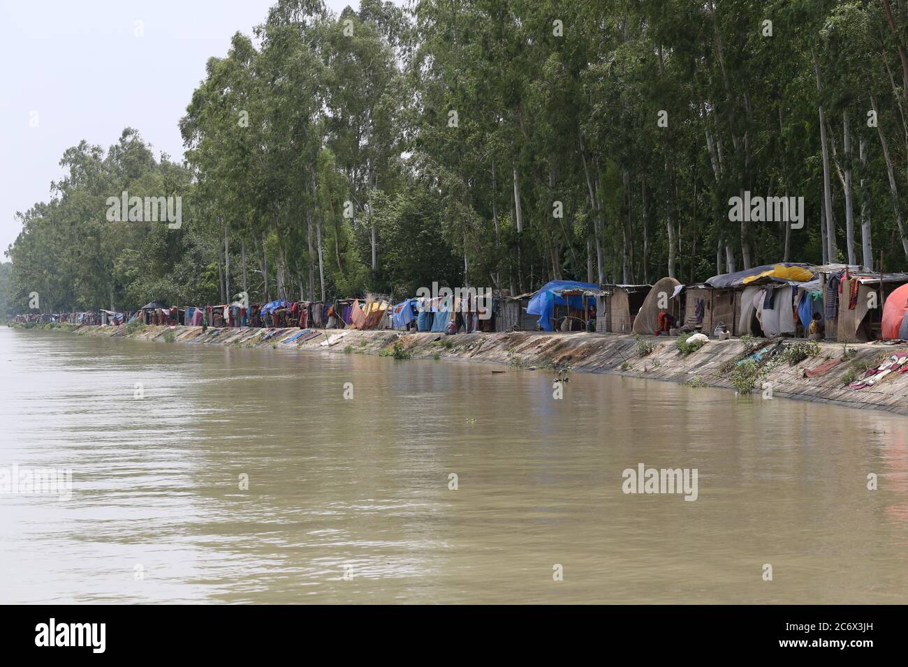 Flood affected people take shelter on a dam during the monsoon flood in ...
