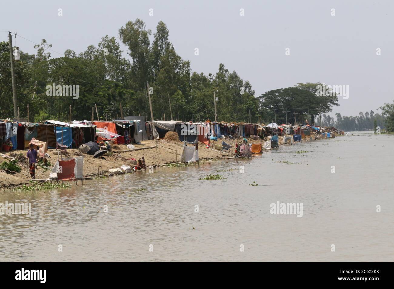 Flood affected people take shelter on a dam during the monsoon flood in ...