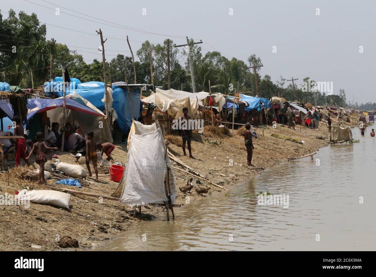 Flood affected people take shelter on a dam during the monsoon flood in ...
