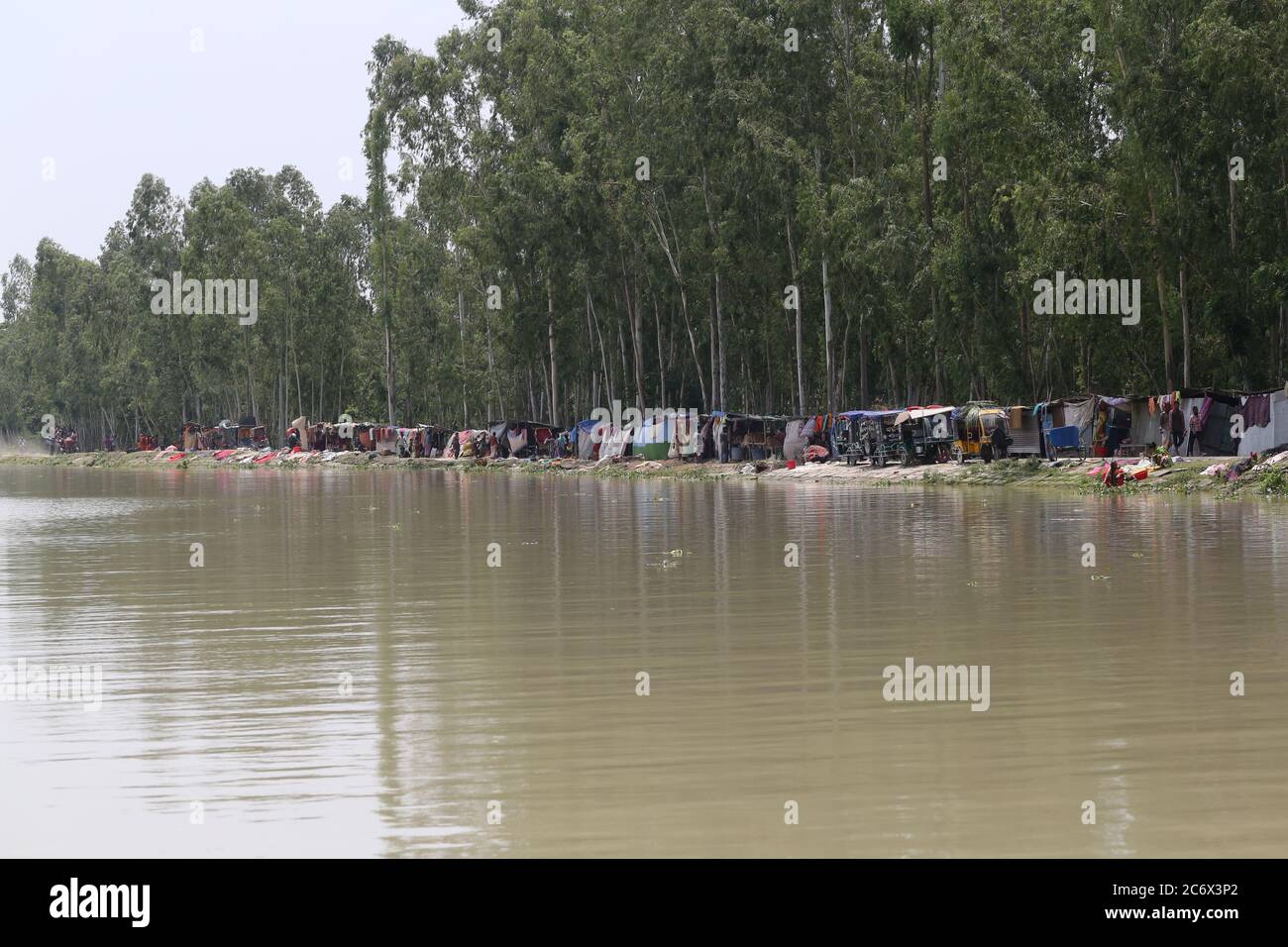 Flood affected people take shelter on a dam during the monsoon flood in ...