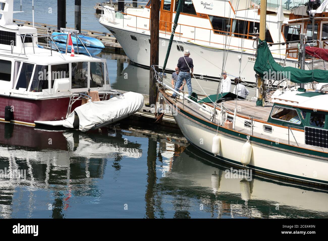 Boaters chat among boats on the docks in the Inner Harbour in downtown ...