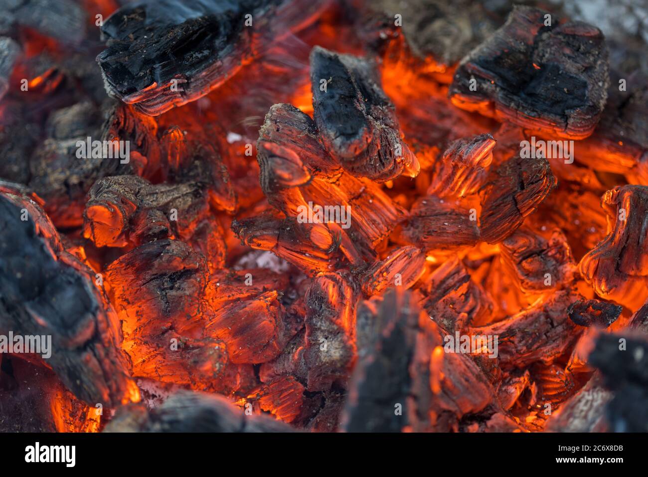 Flame incinerates firewood and transforms it ashes, close up, shallow ...