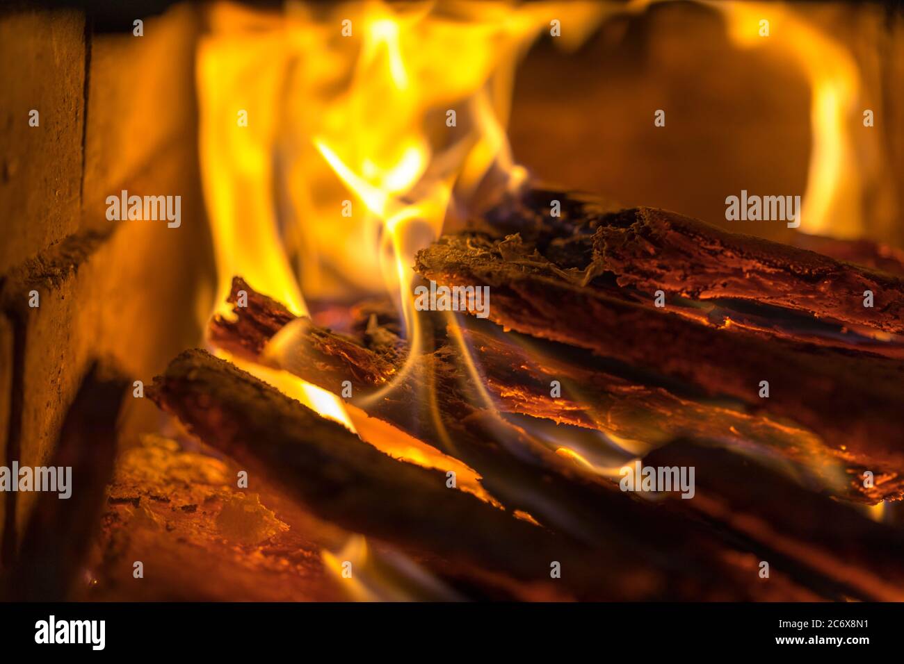 Flame incinerates firewood and transforms it ashes, close up, shallow ...