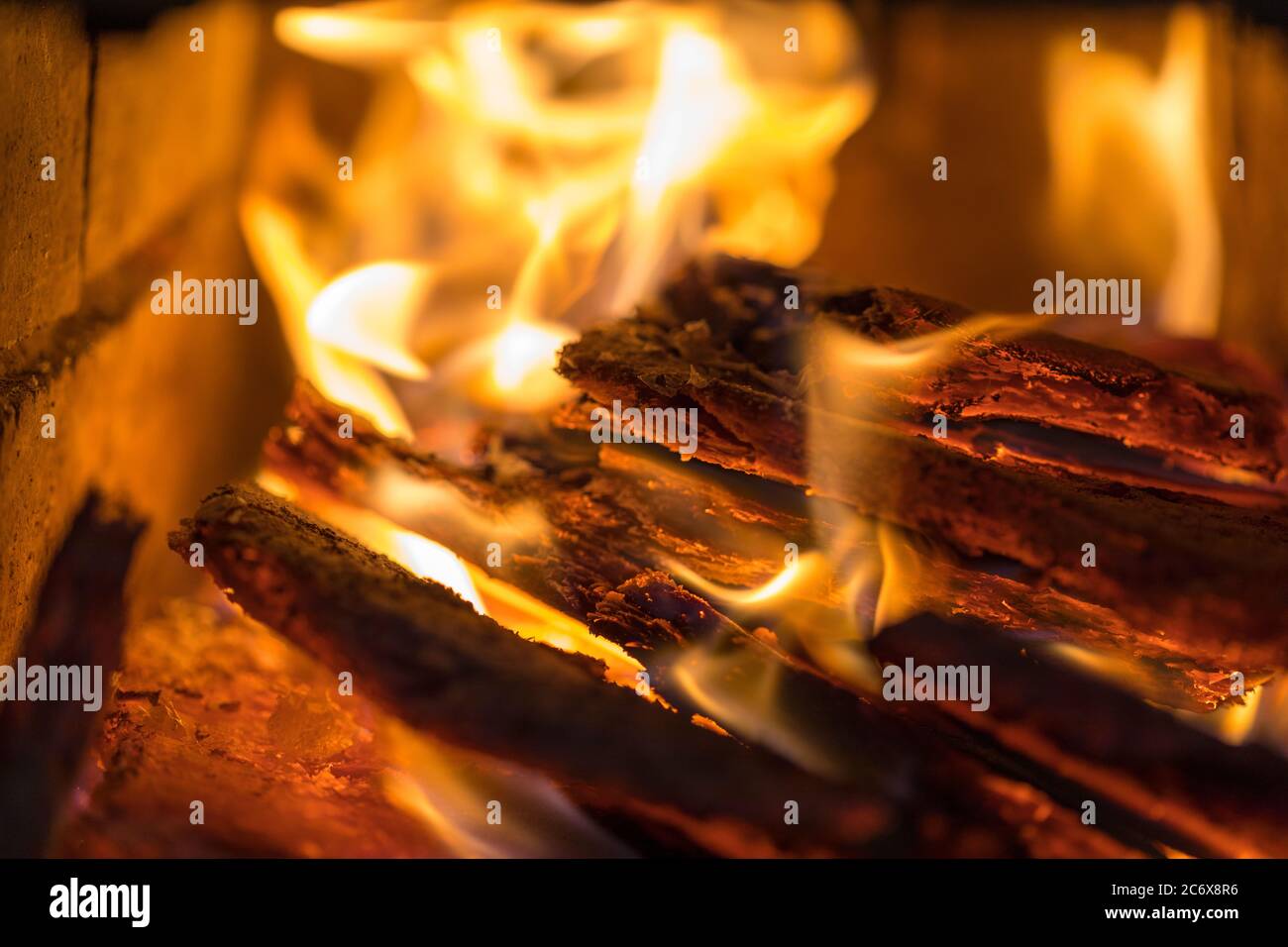 Flame incinerates firewood and transforms it ashes, close up, shallow ...