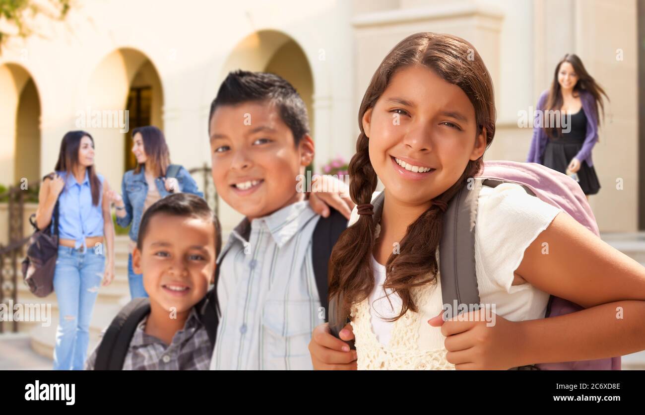 Young Hispanic Student Children Wearing Backpacks On School Campus ...