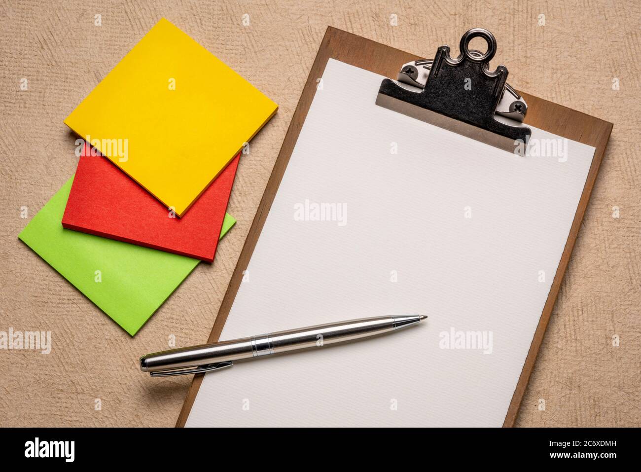 desktop concept - clipboard with blank paper, pen and sticky notes ...