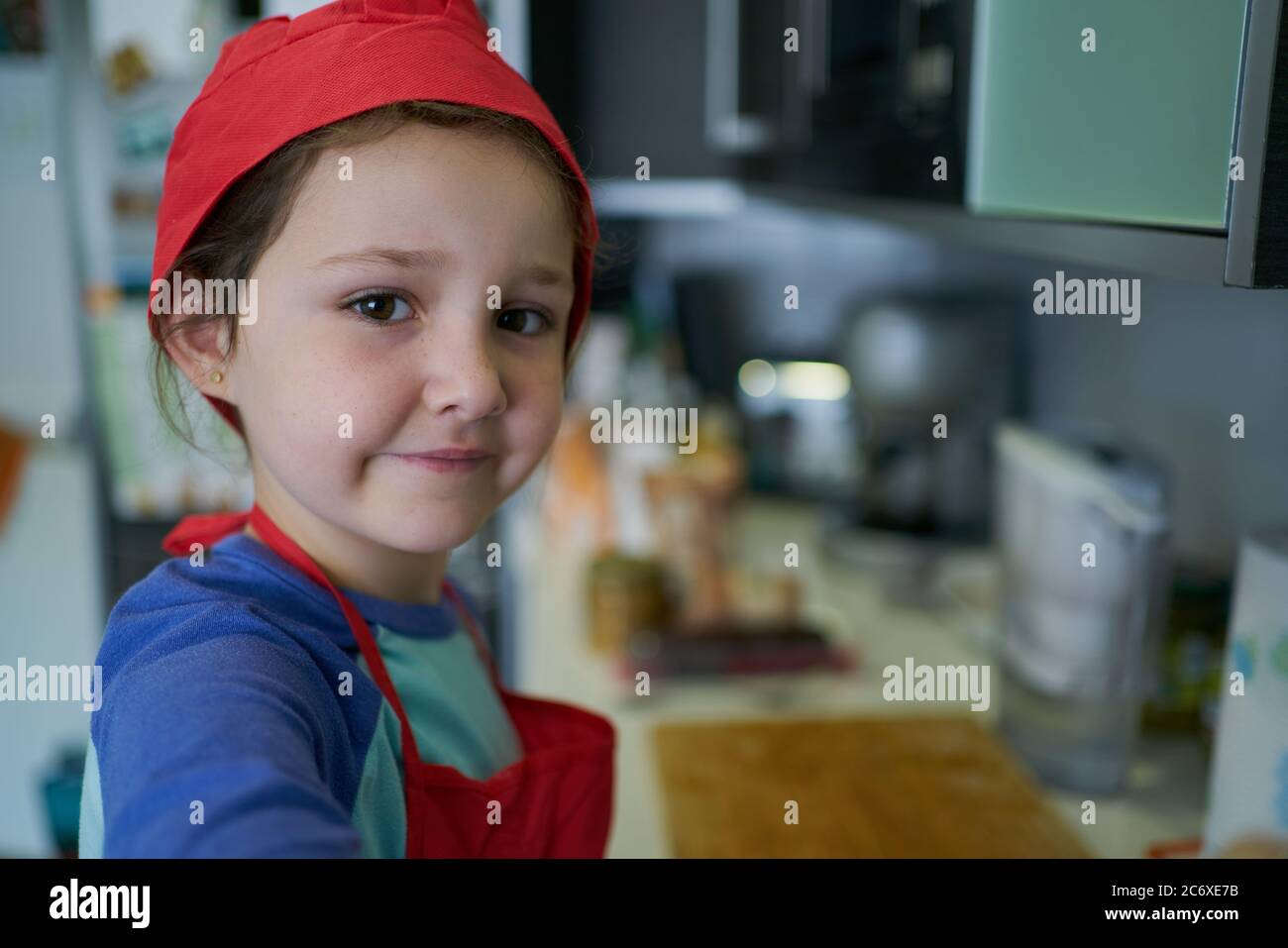 girl in a red chef's hat is in the kitchen of her house Stock Photo - Alamy