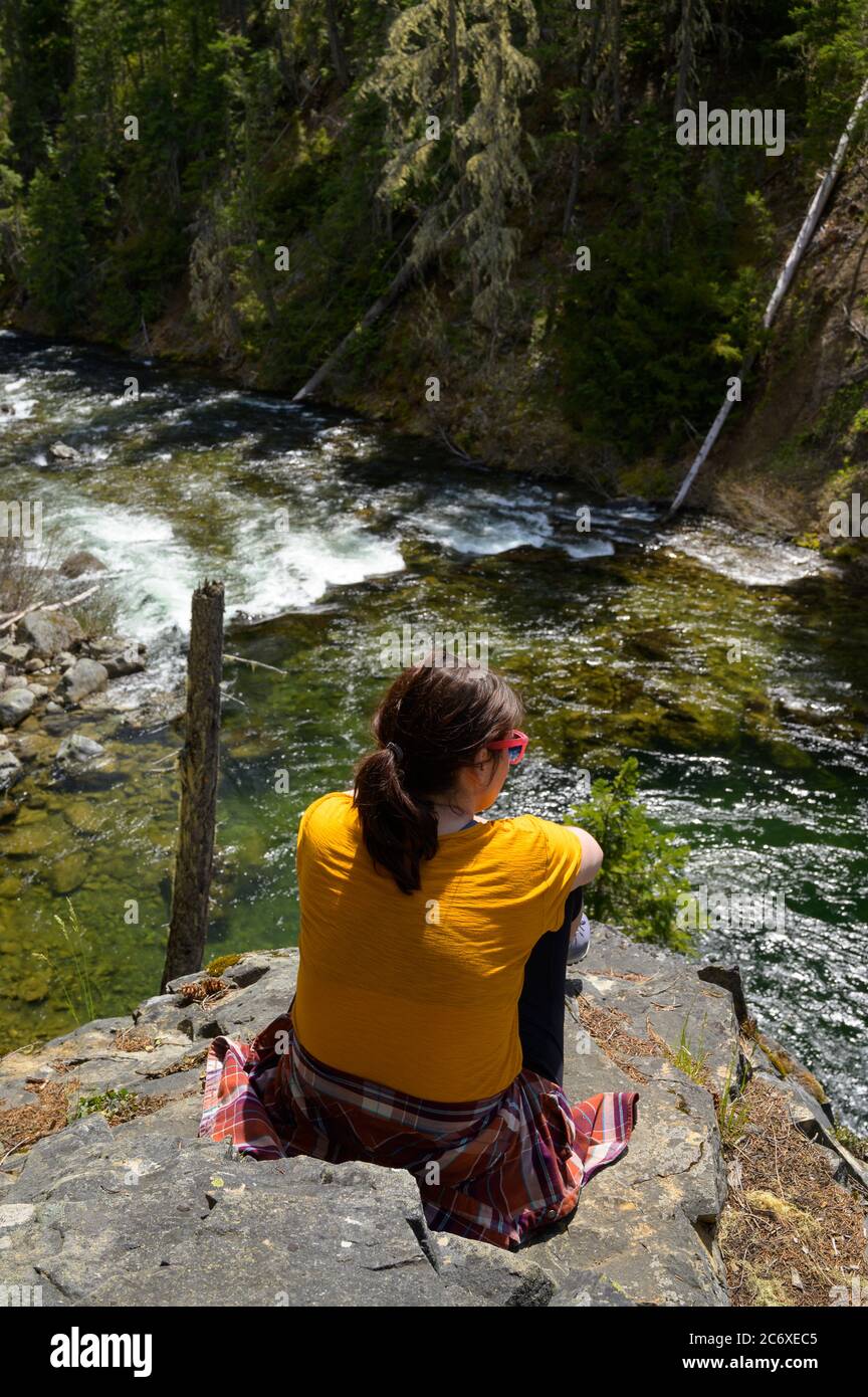 Female Hiker Sitting On Cliff Above River Stock Photo - Alamy
