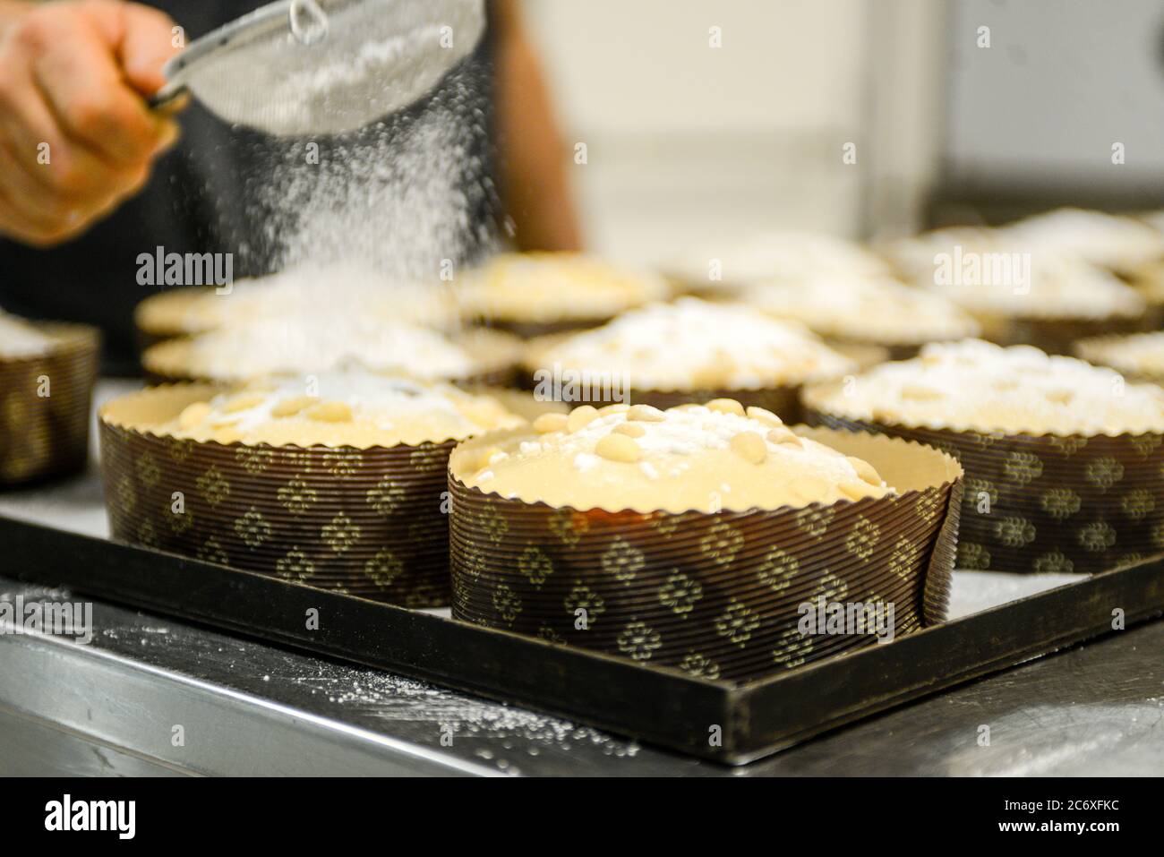 Topping with sugar a group of panettone italian christmas sweet cake ...