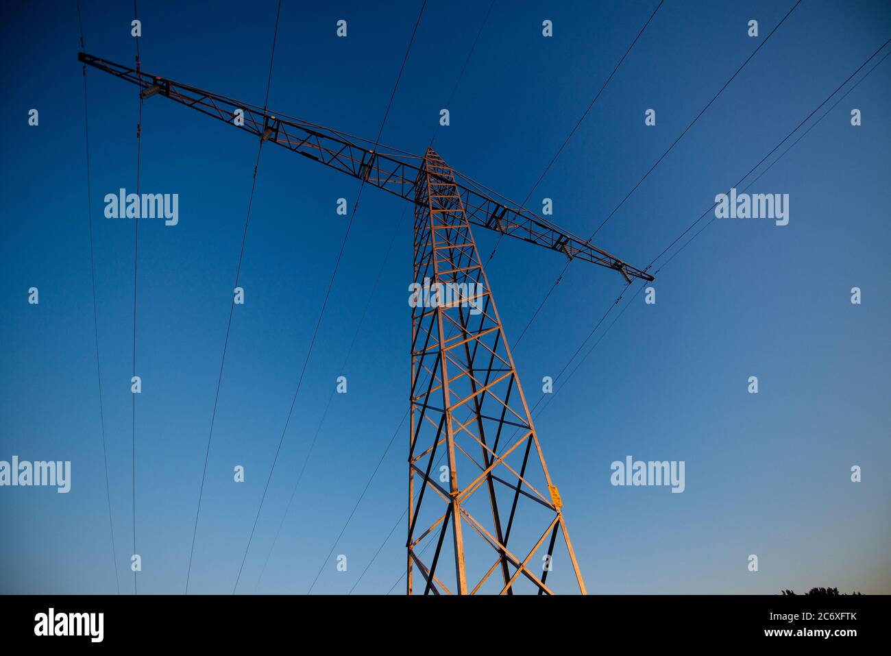 Old powerline in sunset light with blue sky background Stock Photo - Alamy