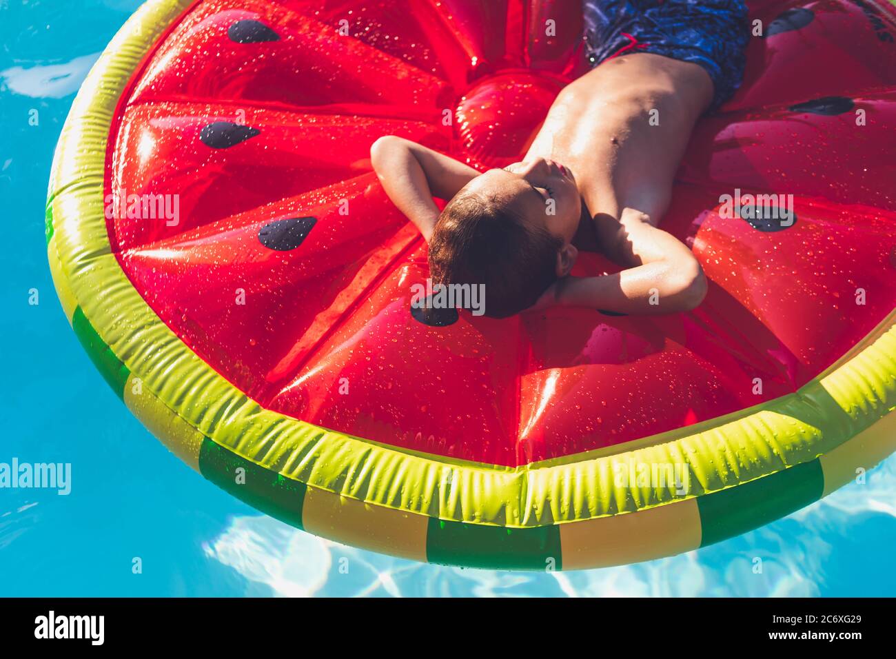Boy chilling in pool on watermelon float Stock Photo - Alamy