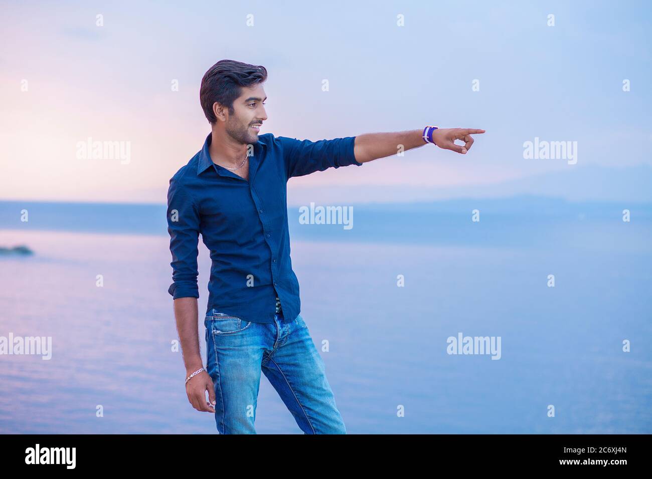 Man pointing finger to something while walking on a shore above the sea ...