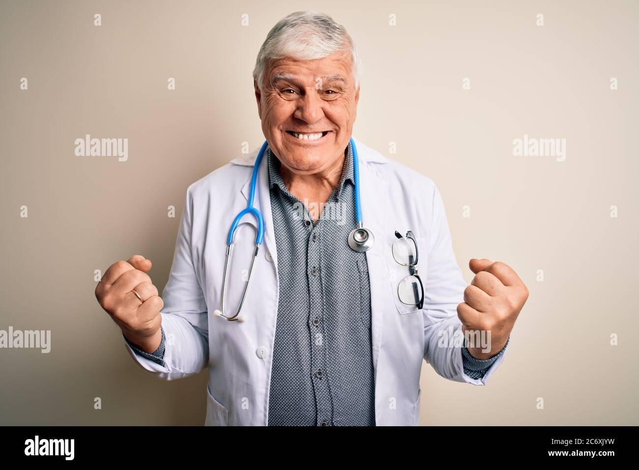 Senior handsome hoary doctor man wearing coat and stethoscope over ...
