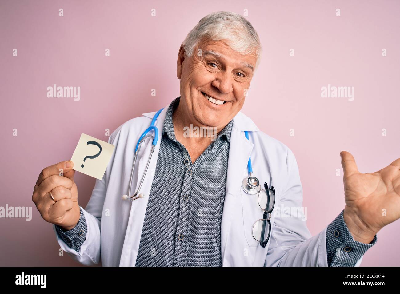 Senior handsome hoary doctor man wearing stethoscope holding reminder ...