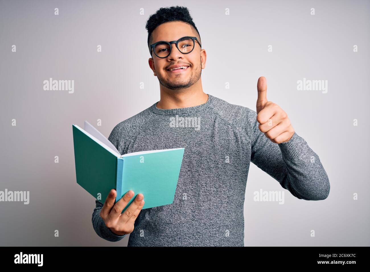 Young handsome smart student man reading book over isolated white ...