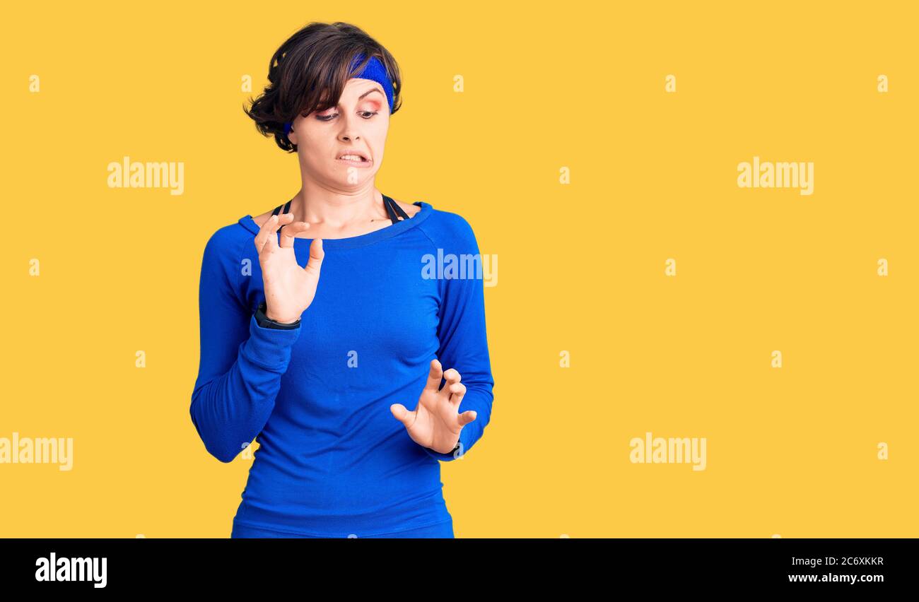 Beautiful young woman with short hair wearing training workout clothes ...