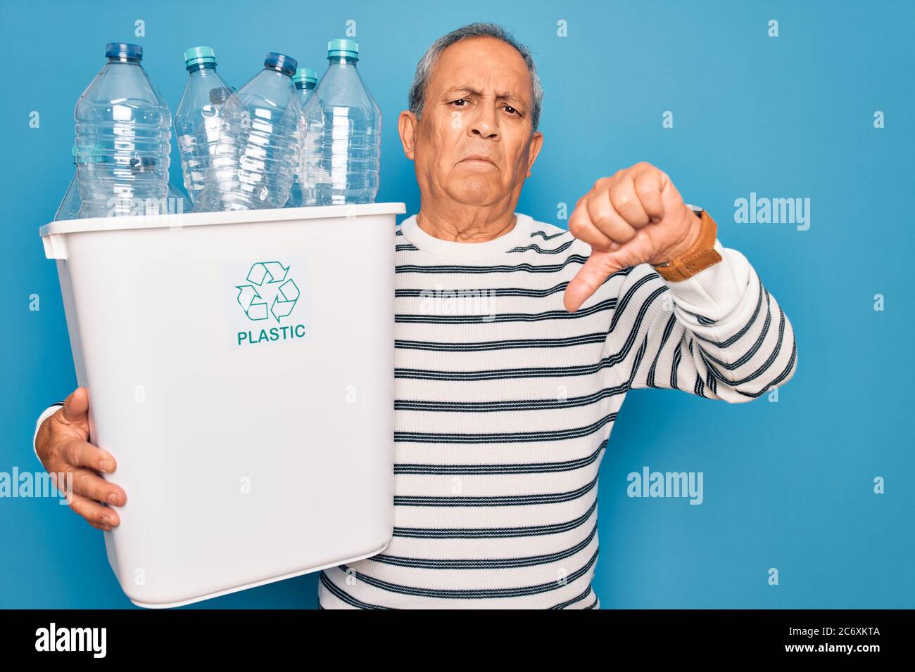 Senior man recycling holding trash can with plastic bottles to recycle ...