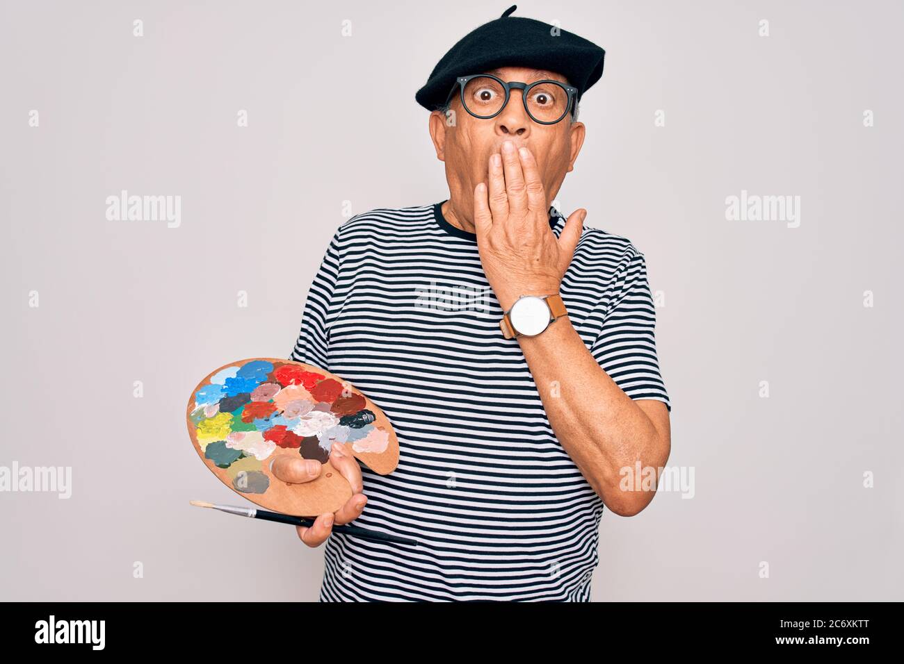 Senior hoary artist man wearing french beret drawing using paintbrush ...