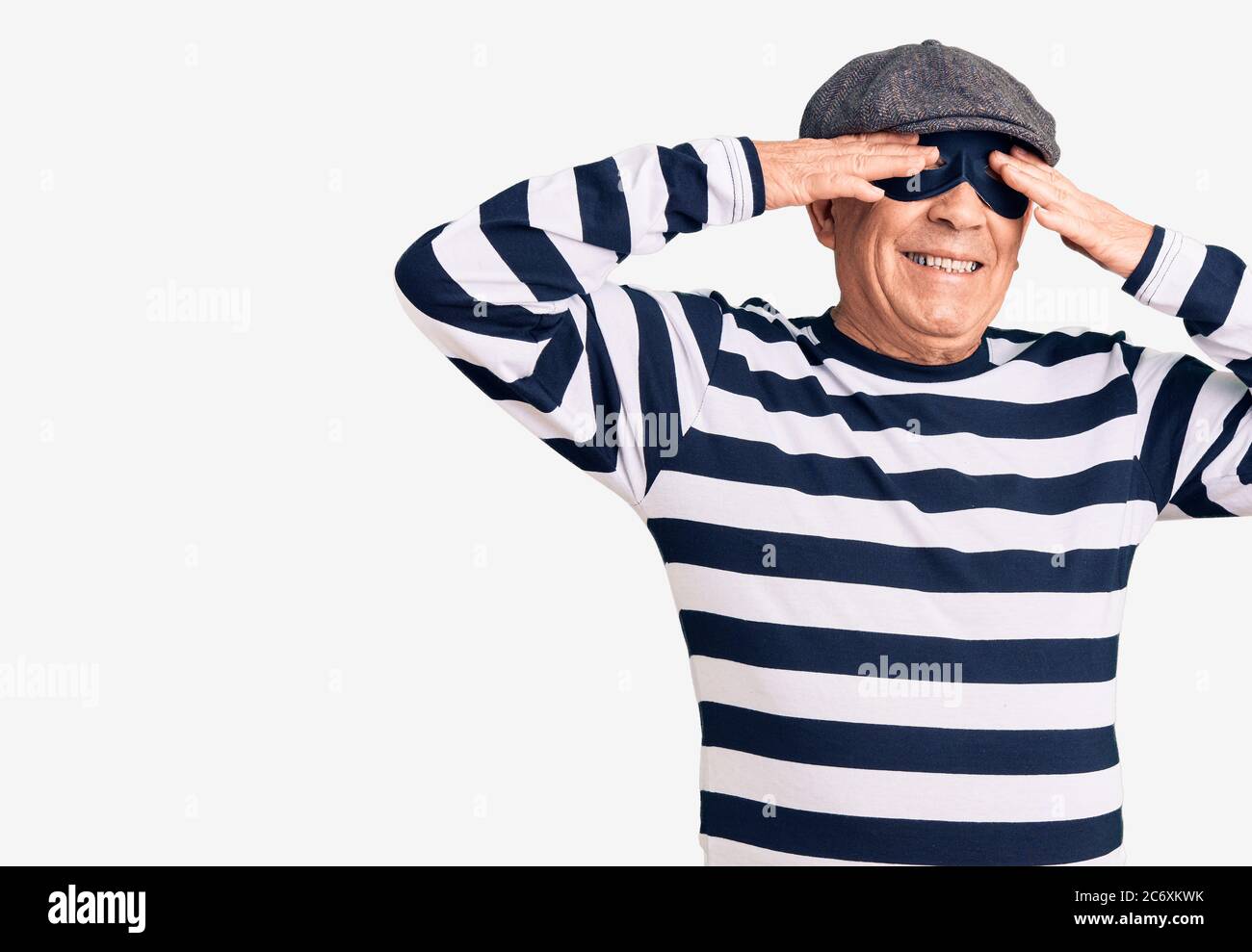 Senior handsome man wearing burglar mask and t-shirt covering eyes with ...