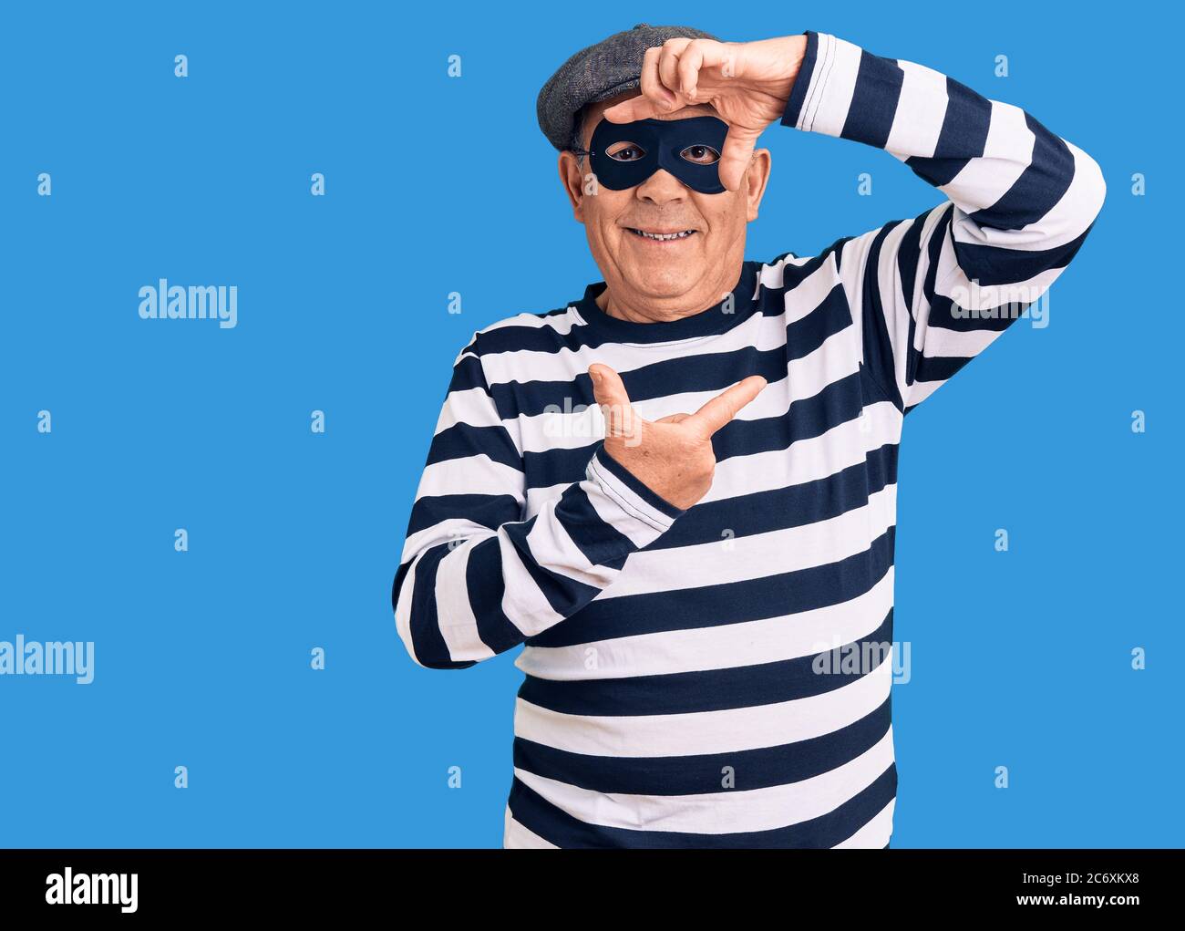 Senior handsome man wearing burglar mask and t-shirt smiling making ...