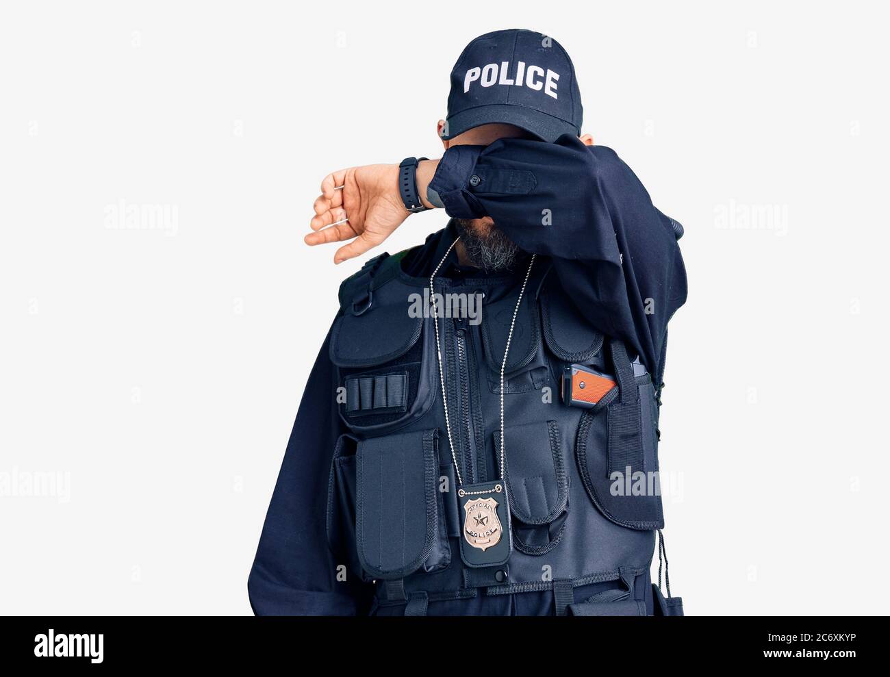 Young handsome man wearing police uniform covering eyes with arm ...