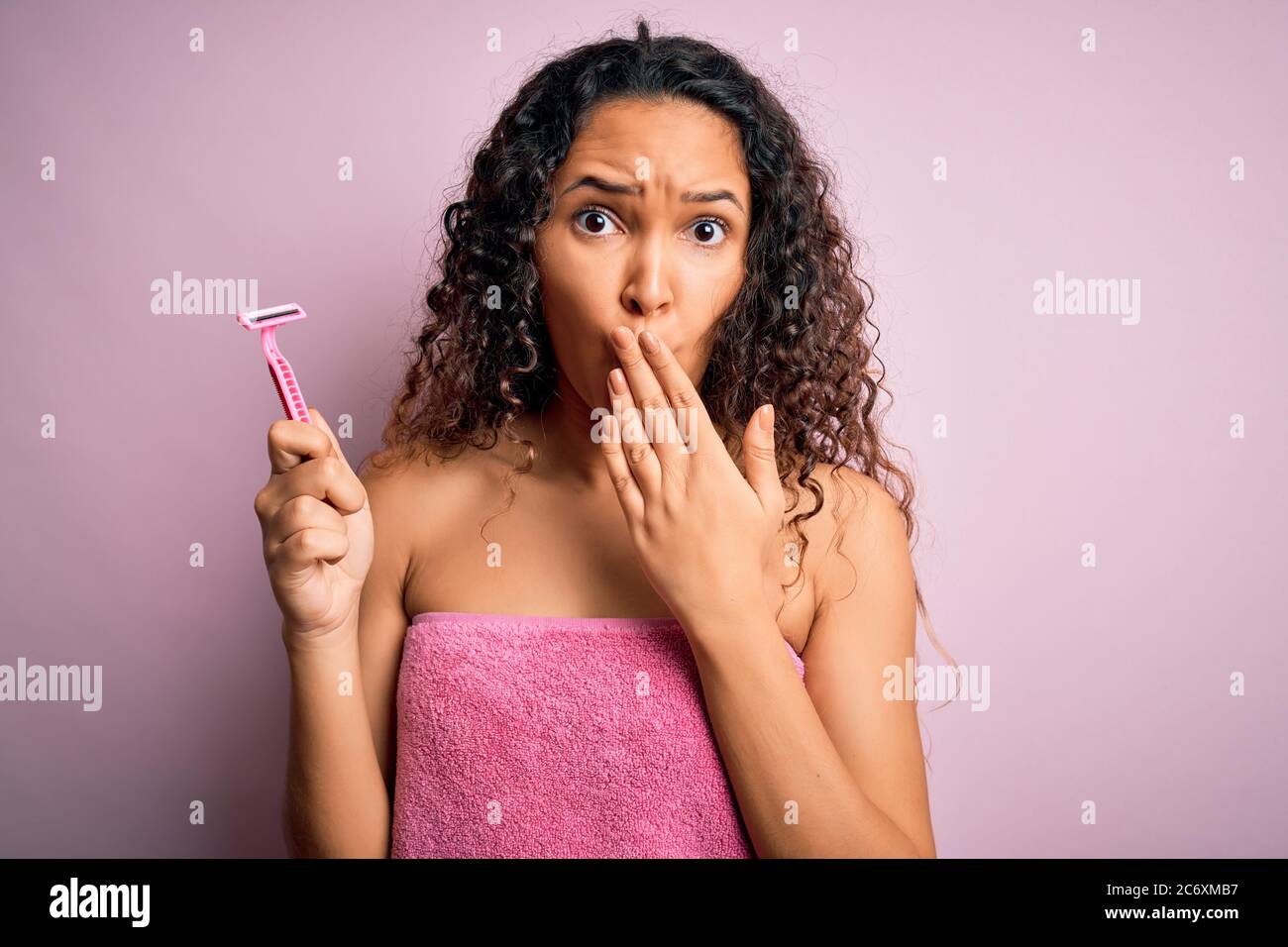 Young beautiful woman with curly hair wearing shower towel holding ...