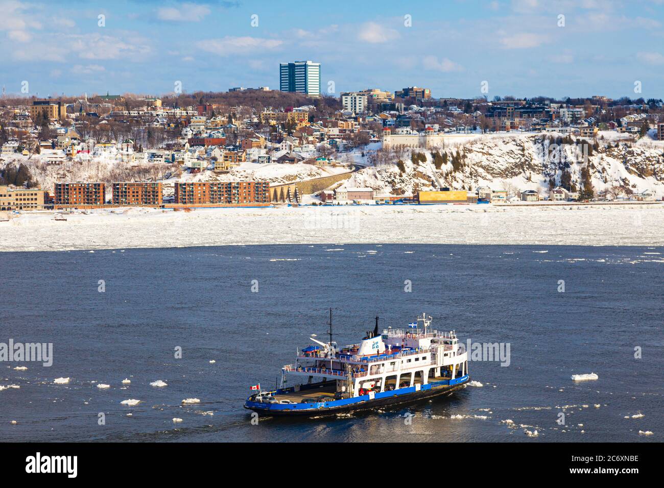 Small car and passenger ferry crossing the St Lawrence River in winter ...