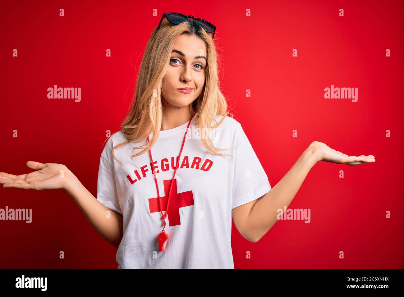 Young beautiful blonde lifeguard woman wearing t-shirt with red cross ...