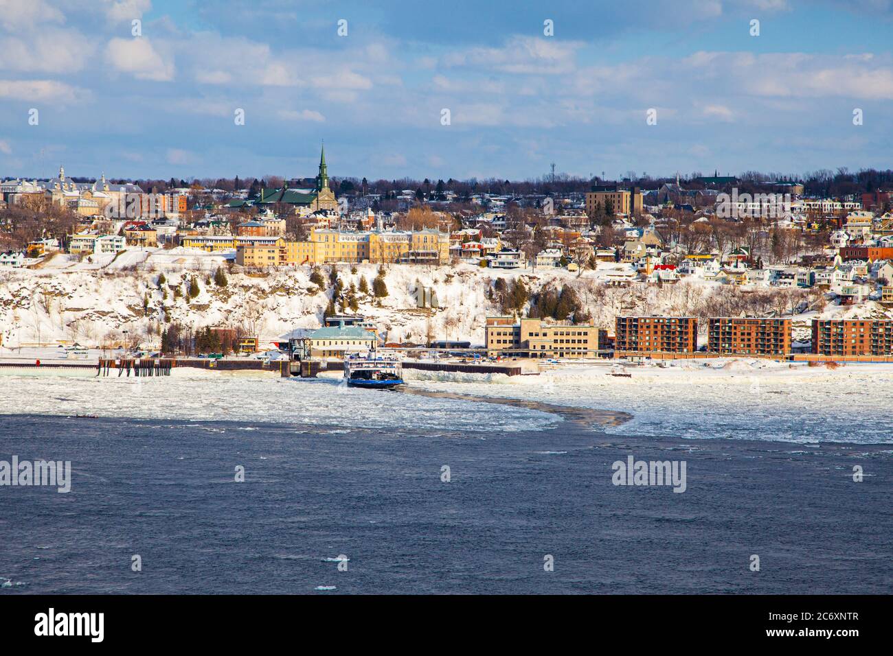 Small car and passenger ferry crossing the St Lawrence River in winter ...