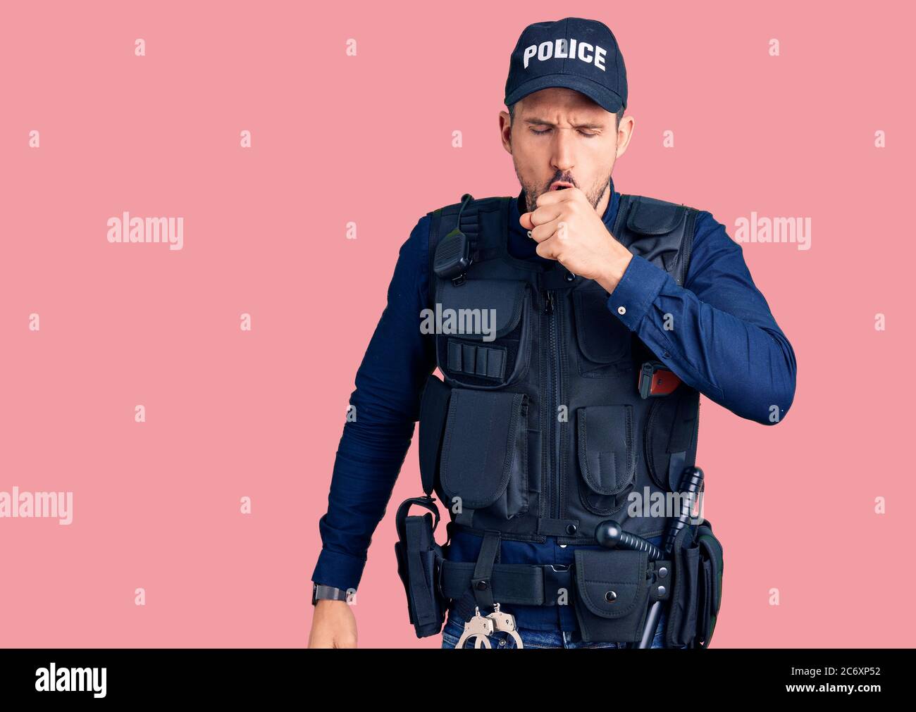 Young handsome man wearing police uniform feeling unwell and coughing ...