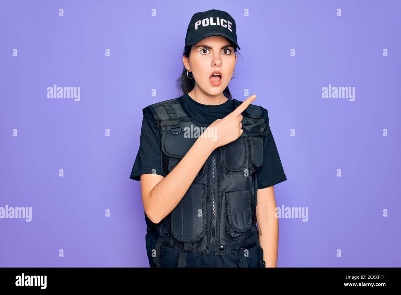 Young police woman wearing security bulletproof vest uniform over ...