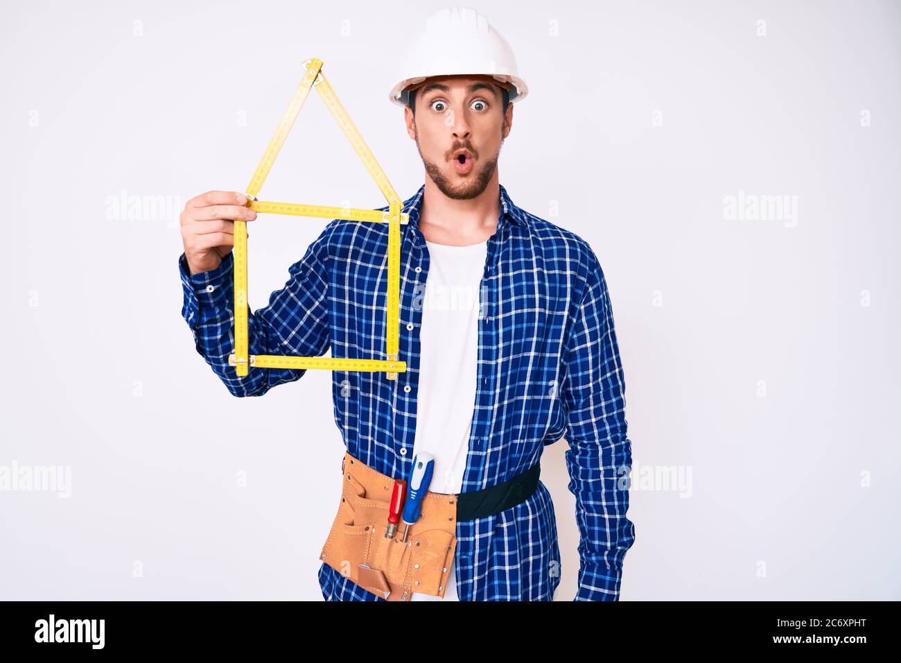 Young handsome man wearing architect hardhat holding build project ...