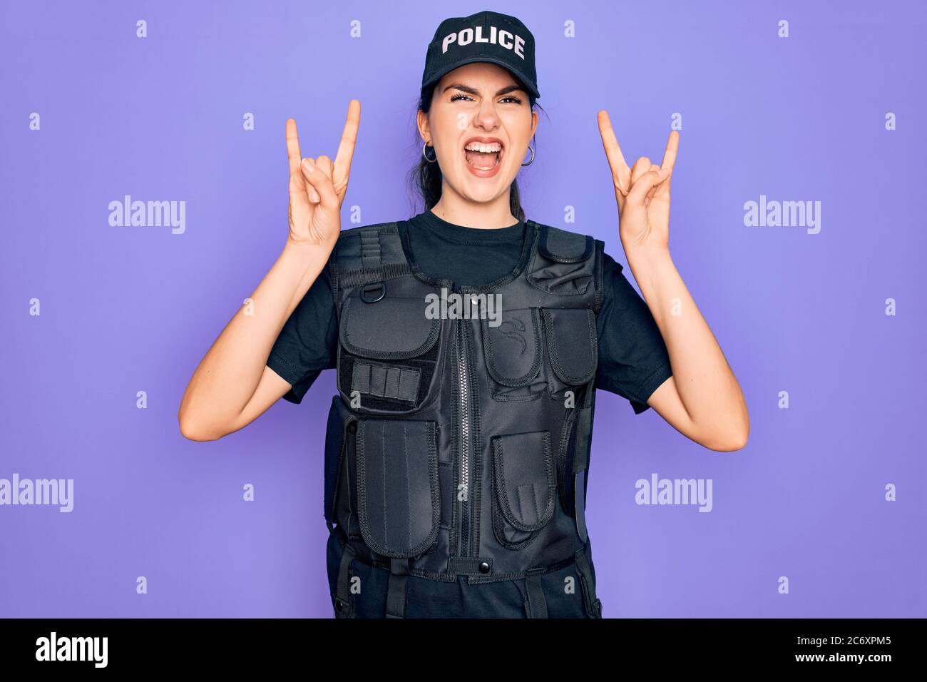 Young police woman wearing security bulletproof vest uniform over ...