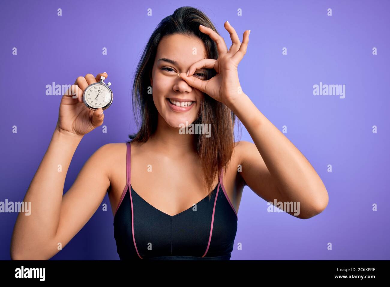 Young beautiful sporty girl doing sport using stopwatch over isolated ...