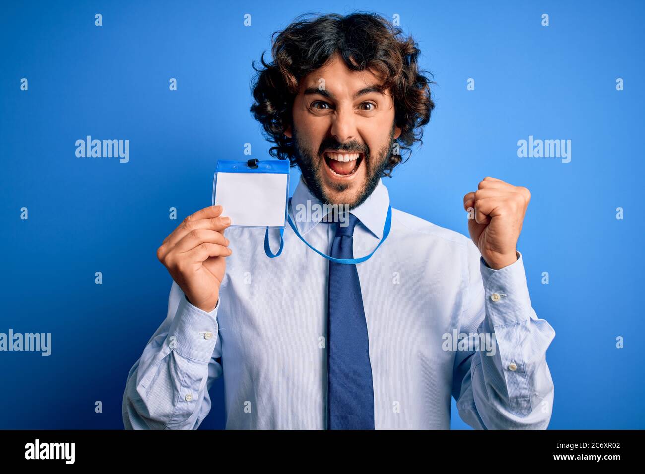 Young handsome business man with beard holding id card identification ...