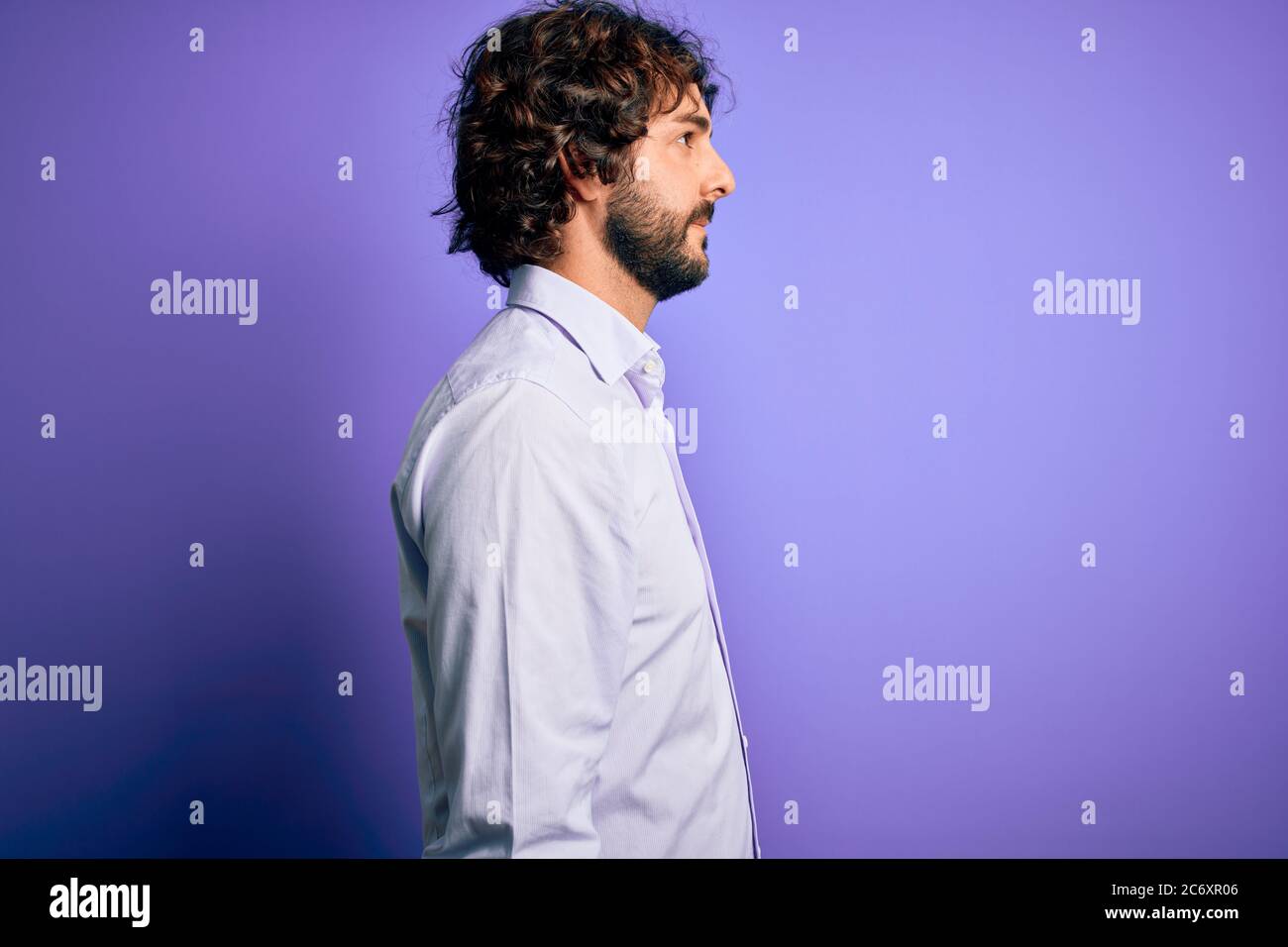 Young handsome business man with beard wearing shirt standing over ...