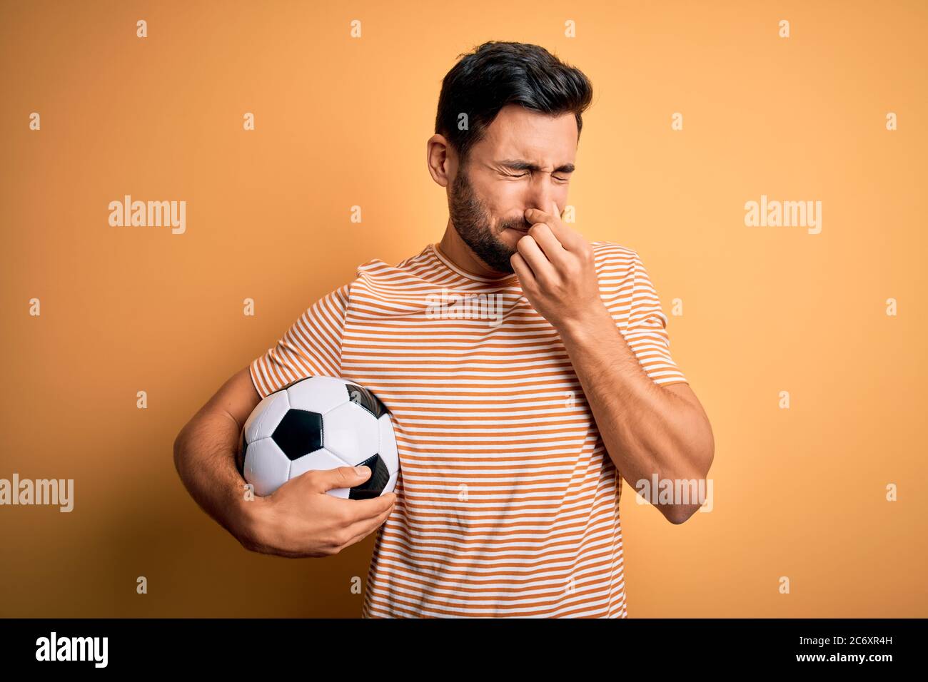 Handsome player man with beard playing soccer holding footballl ball ...