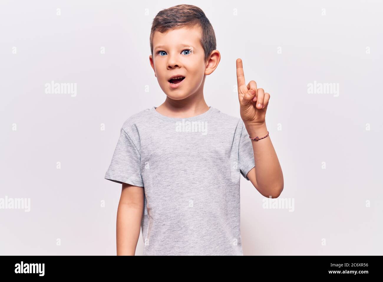 Cute blond kid wearing casual clothes pointing finger up with ...